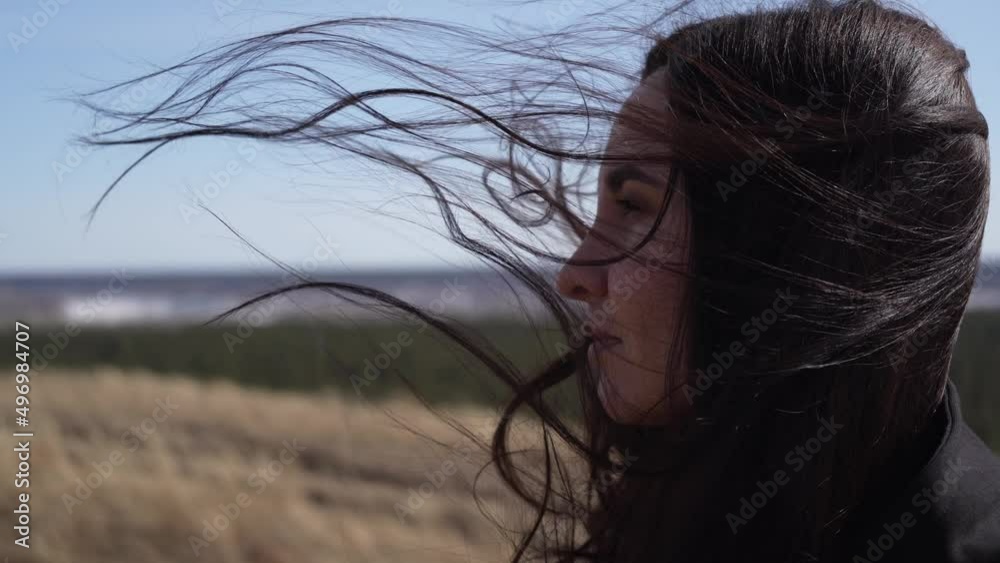 the wind blows the girl's hair. close-up of a woman's face with hair ...