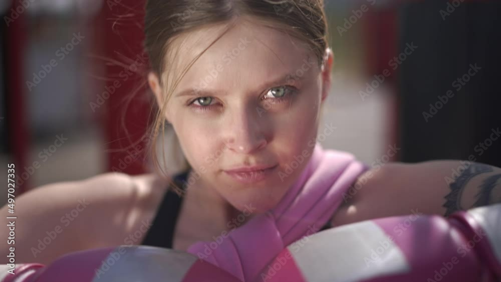 Headshot of confident Caucasian female boxer looking at camera punching ...