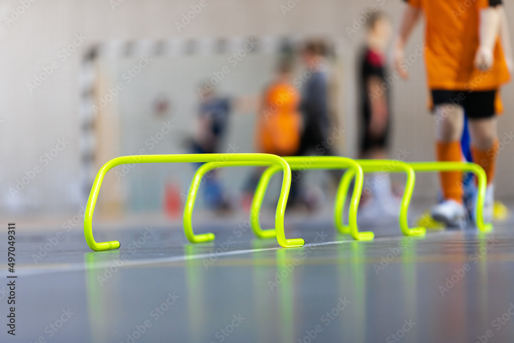 Foto de Indoor sports training with yellow hurdles. Young boy running ...