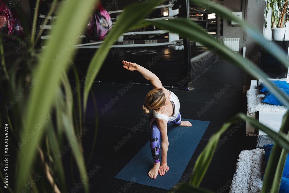 Asana side triangle, the girl practices yoga on the mat in the fitness ...