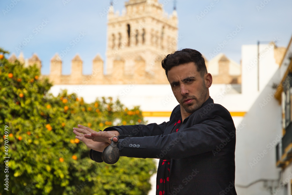 gypsy man dancing flamenco, dressed in black with castanets is posing ...