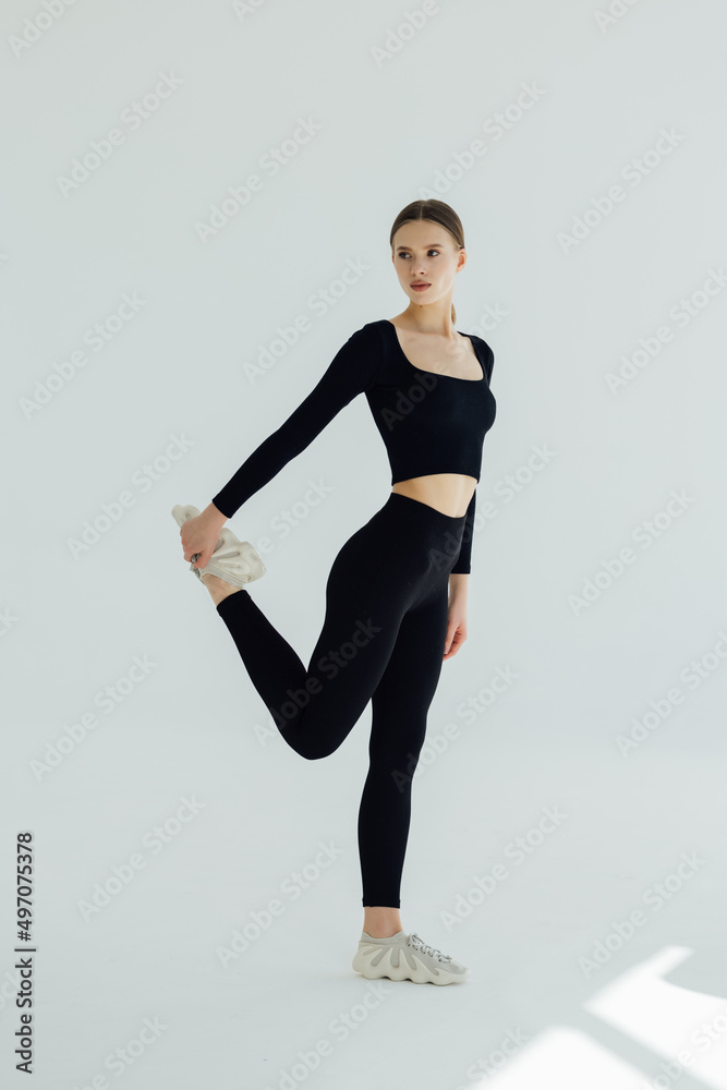 Athletic fitness woman helthy sport do legs exercises isolated white ...