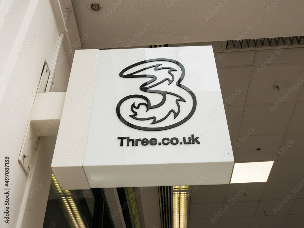 London, England, April 2nd 2022: The Three logo shop display sign ...