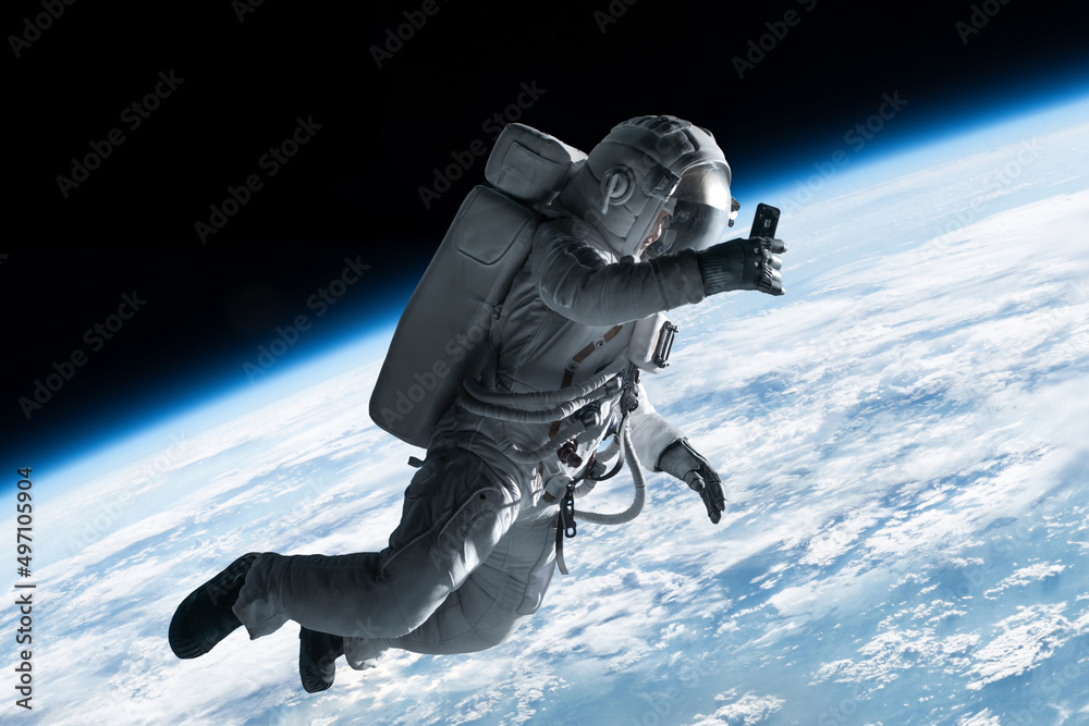 Female astronaut having a video call on her phone while performing ...