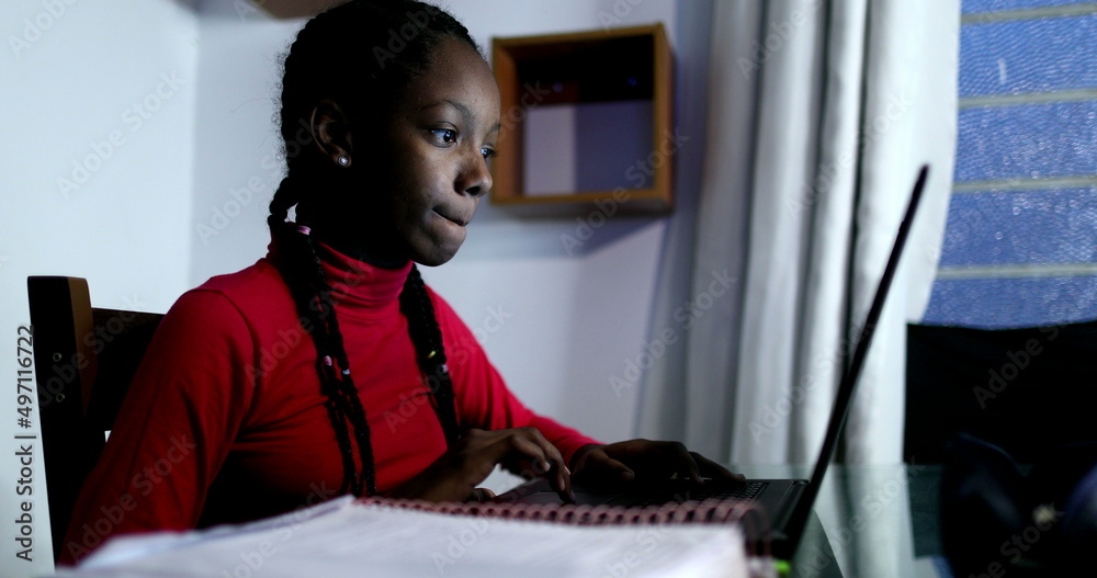 Teen African girl doing homework at night, black adolescent female ...