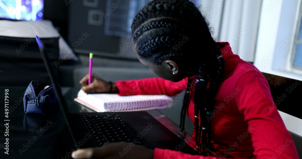 Teen African girl doing homework at night, black adolescent female ...