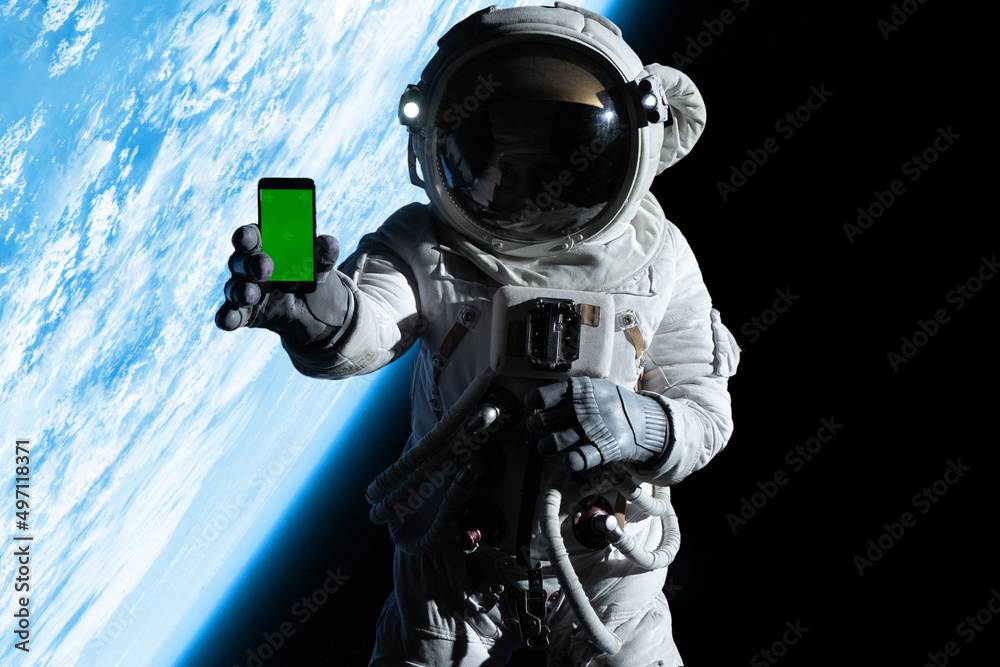 Astronaut showing a screen of a phone into a camera while performing ...