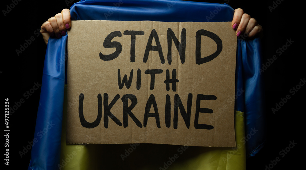 Woman holding Ukrainian flag and "Stand With Ukraine" placard sign in ...