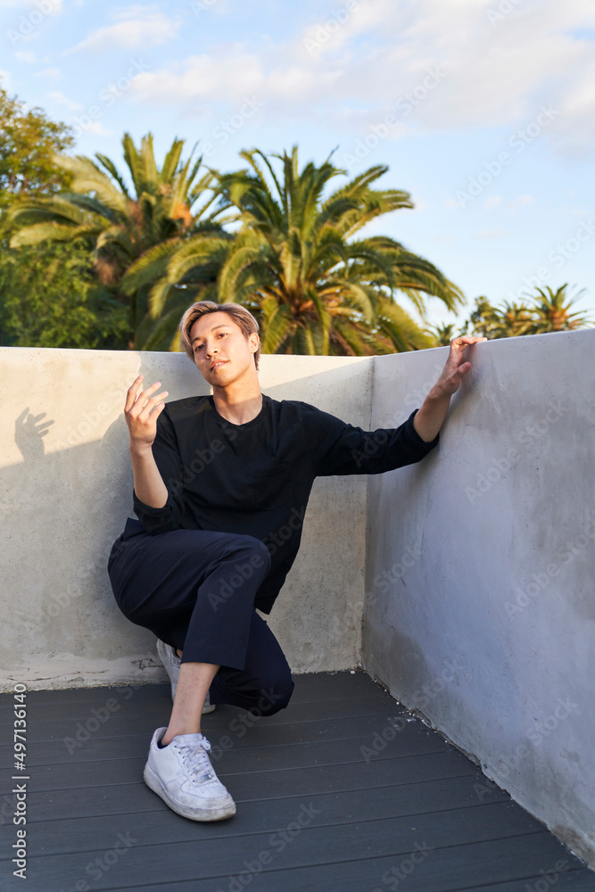 Man dancing kneeling with blue sky and palm trees Stock Photo | Adobe Stock