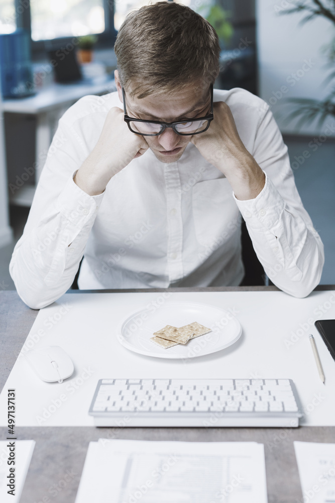 Sad office worker eating a very small meal Stock Photo | Adobe Stock