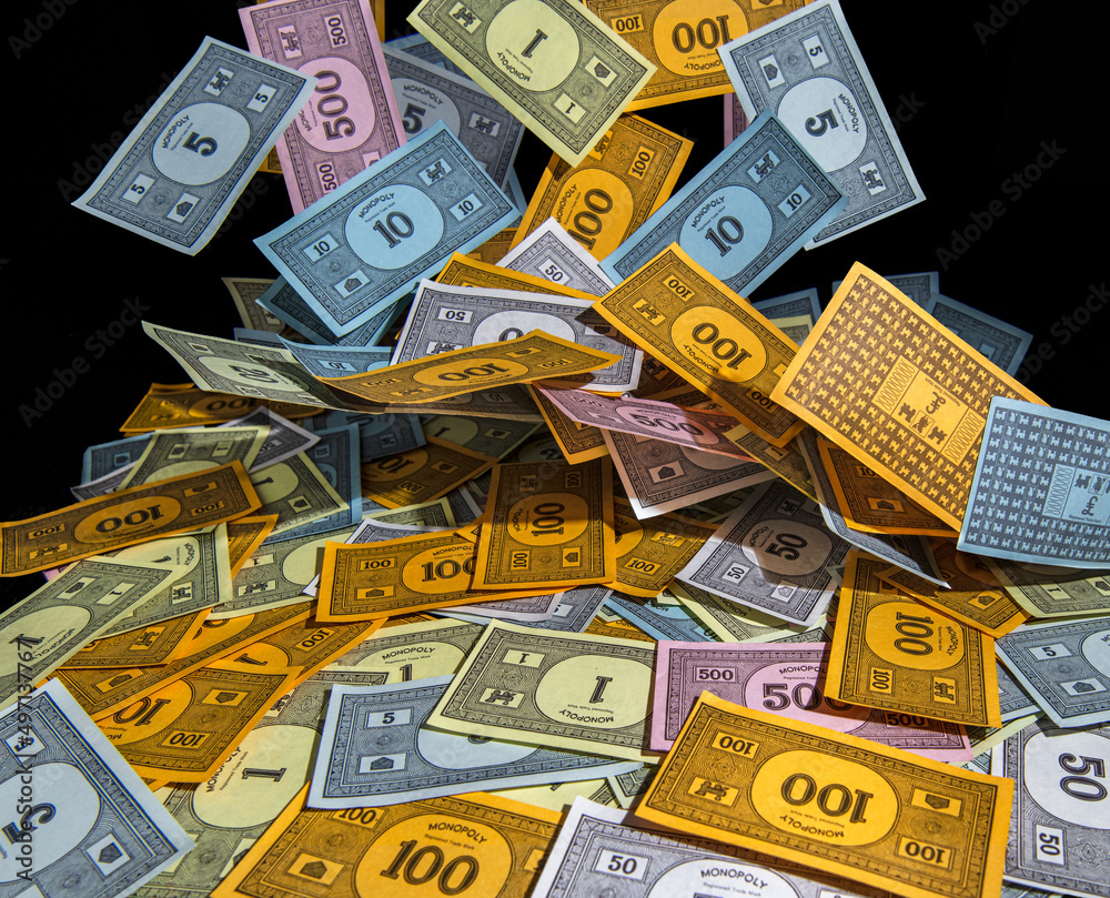 Monopoly money Falling into a pile Stock Photo | Adobe Stock