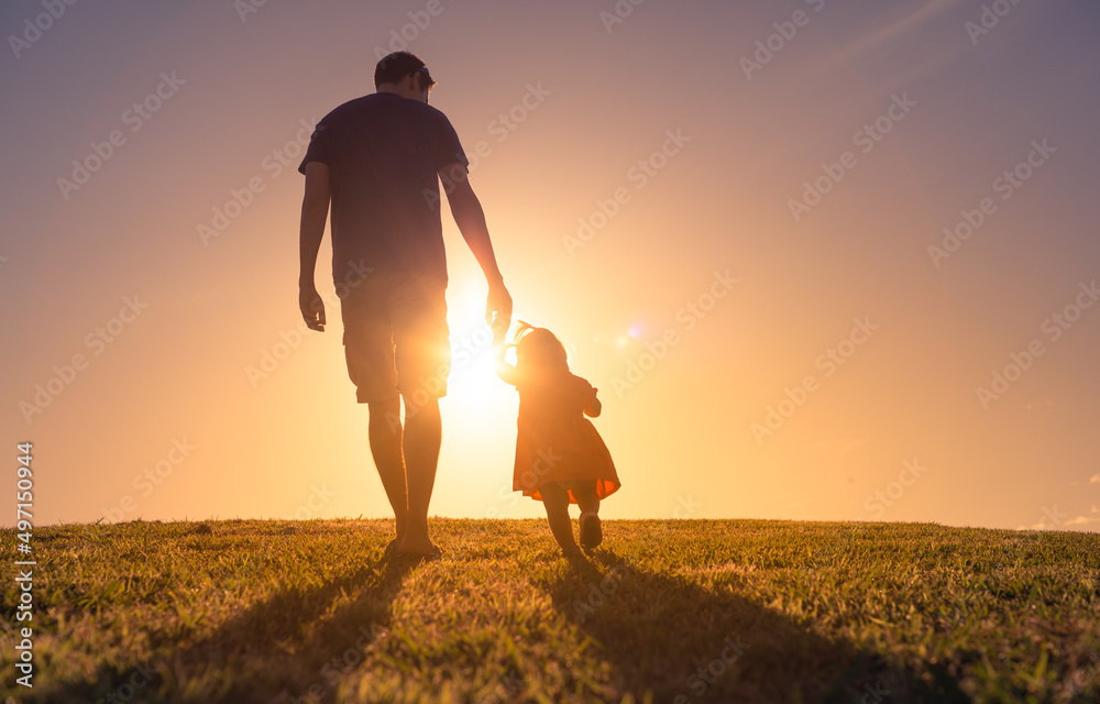 Silhouette of loving father walking side by side with child daughter ...