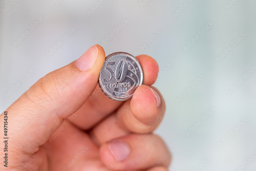 Foto de Brazilian 50 cents coin in the palm of a person. Hand holding a ...