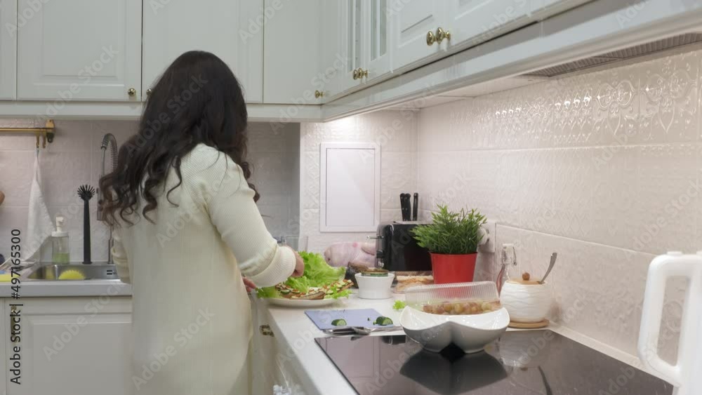 Woman cooking festive dinner in the kitchen making toast with cucumber ...