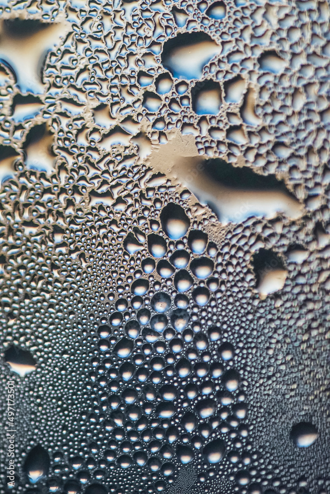 drops of water on a glass. water drops on blue and yellow background ...