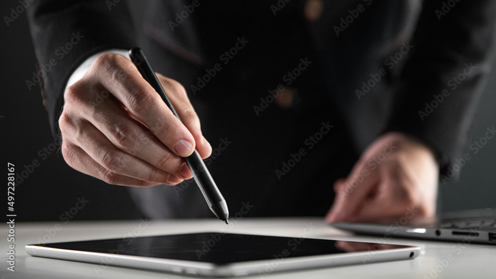 Close up of businessman using electronic pencil or stylus pen signing ...