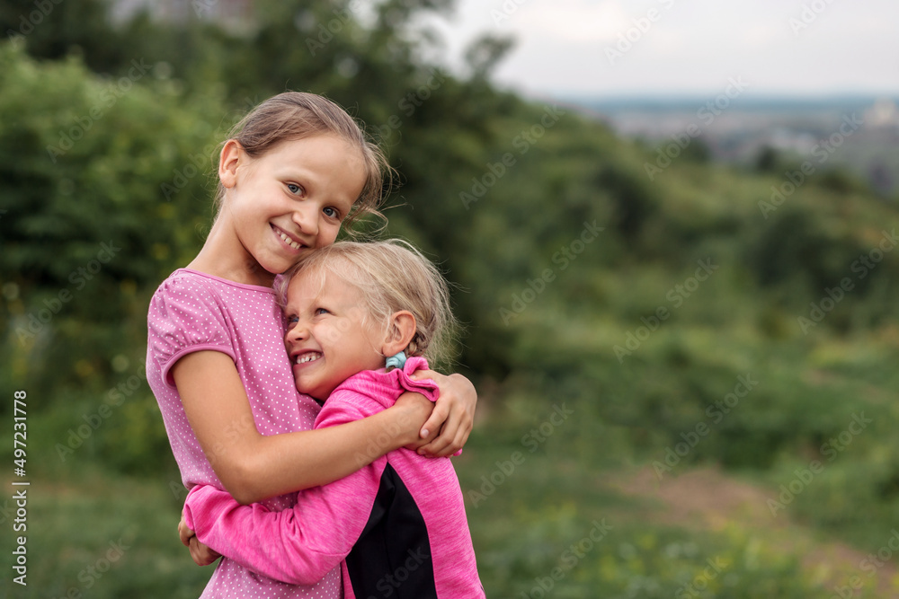 Children hug tightly in nature. Long-awaited meeting after separation ...