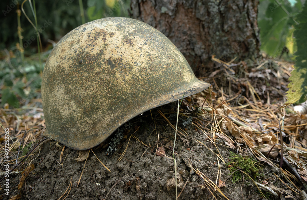 An old soldier's helmet on the ground. A rusty helmet from the war in ...