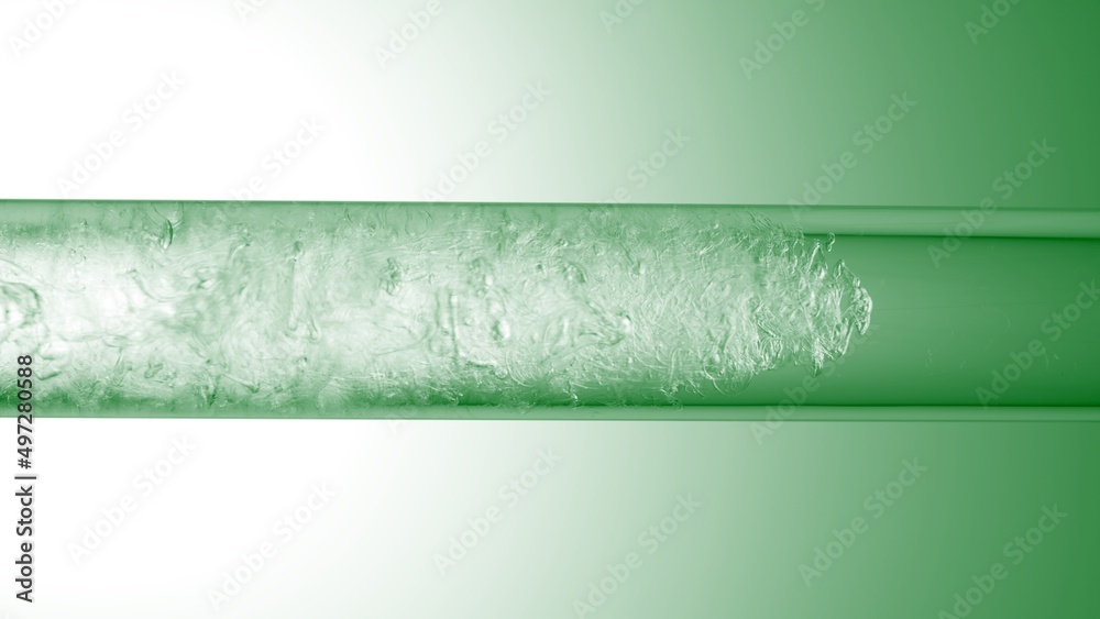 Glycerine is being poured in glass tube with transparent fluid on green ...