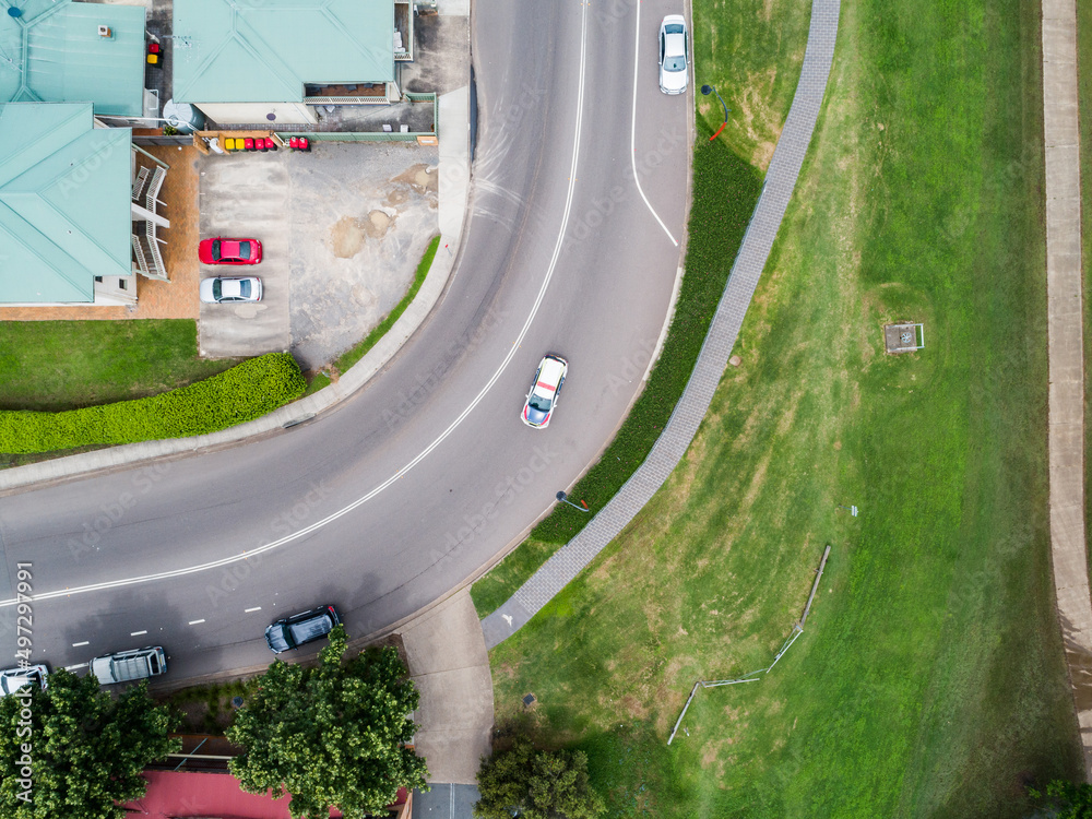 Car driving on curved corner bend in road in town from above Stock ...