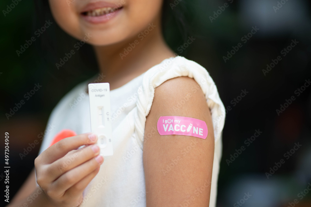 Asian little girl showing plaster with COVID-19 rapid test kit - home ...