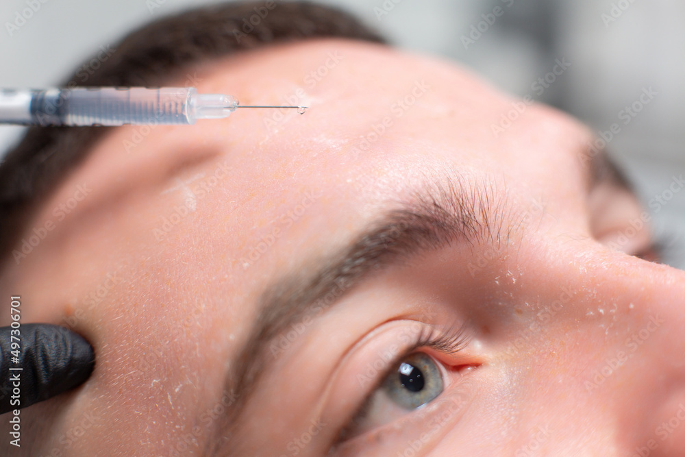 Close up of a drop of a drug falling from a syringe needle on the ...