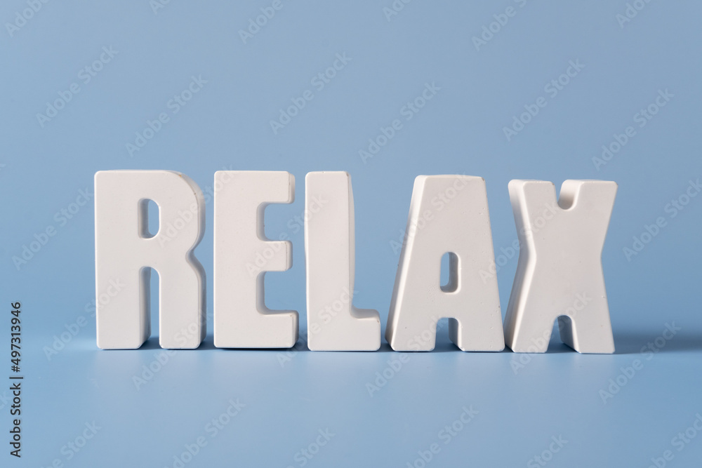 Word Relax made from white concrete letters on the blue background ...