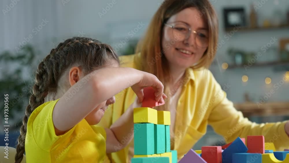 mom and daughter play with cubes a toys blocks. childhood kindergarten ...