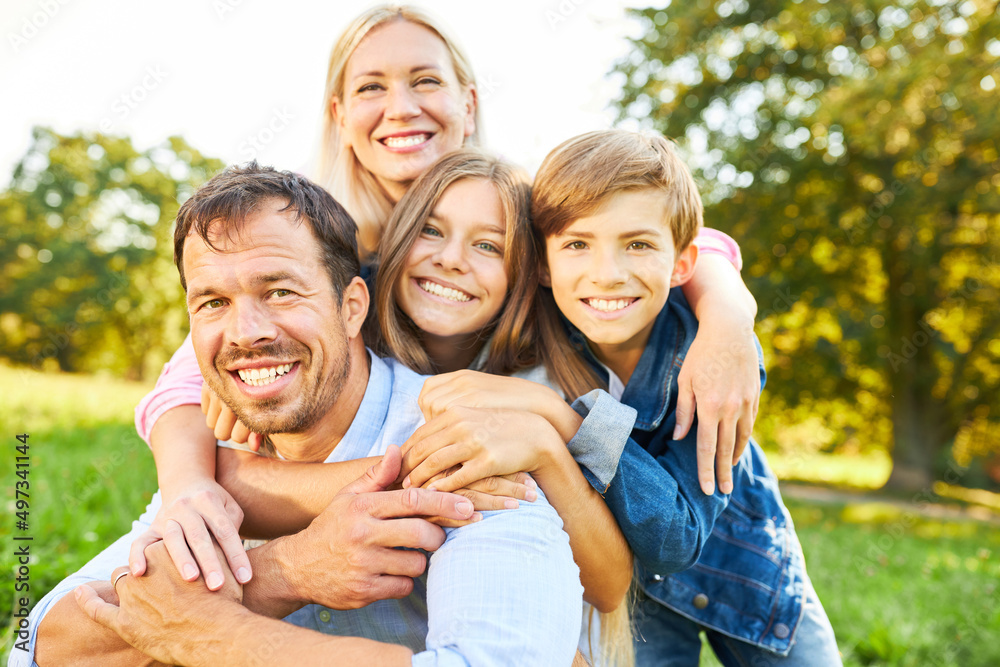 Glückliche Familie mit zwei Kindern im Garten Stock Photo | Adobe Stock