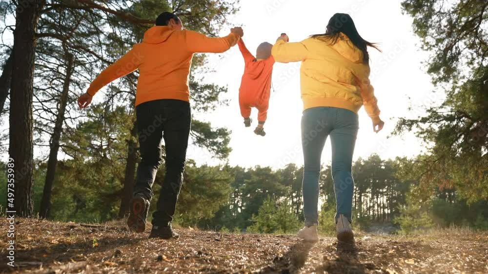 happy family. parents run with baby throw him up holding hands ...