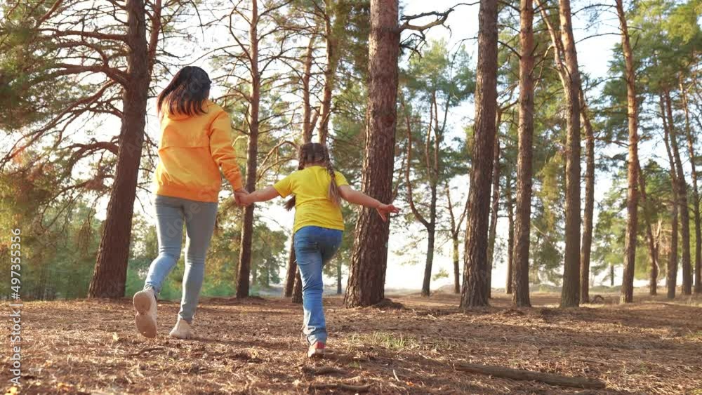 happy family run. mother and daughter a running through the forest park ...