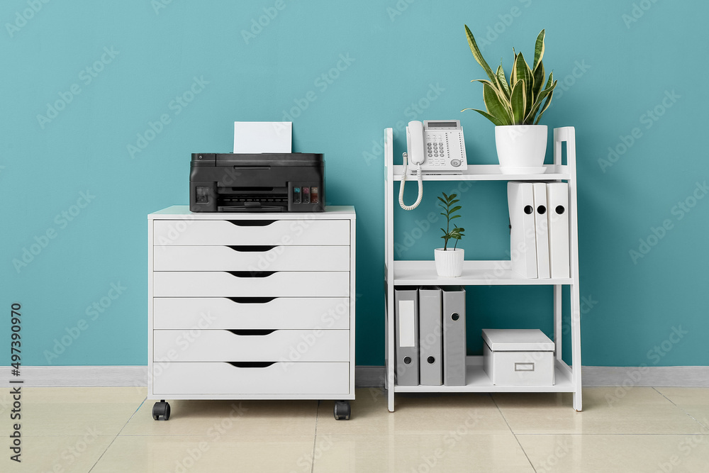 Chest of drawers with modern printer and shelf unit near color wall in ...