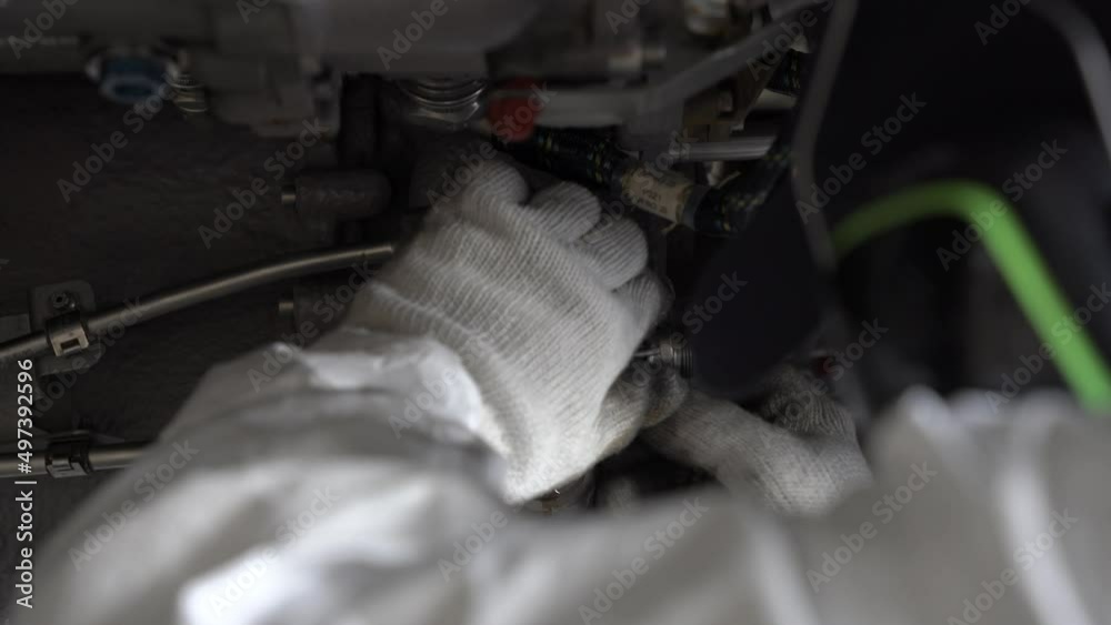 Aircraft technician removing a magnetic chip detector from an engine ...