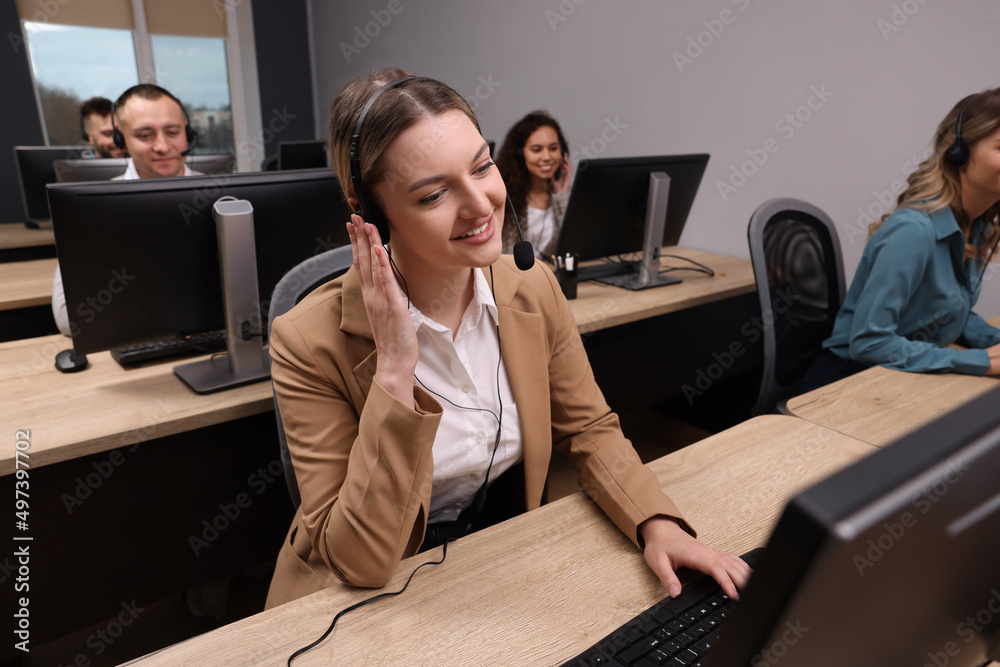 Call center operators working in modern office, focus on young woman ...