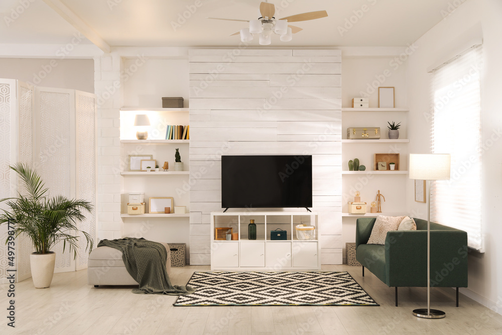 Cozy room interior with stylish furniture, decor and modern TV set ...