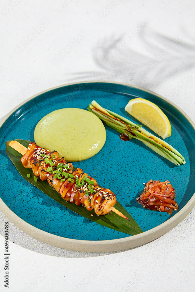 Squid yakitori in ceramic dish on white background. Japanese skewered ...