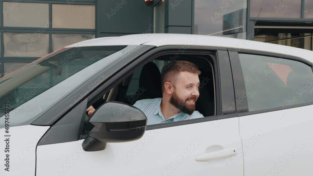 Caucasian bearded man taking white luxury car for test drive from ...