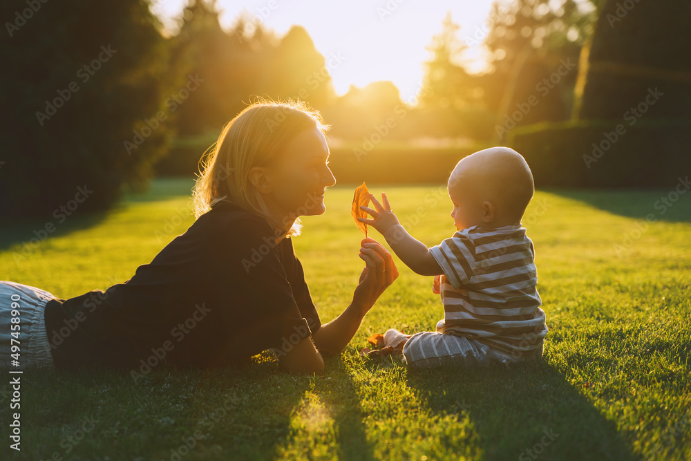 Young mother and baby playing in park at summer. Beautiful mom and ...