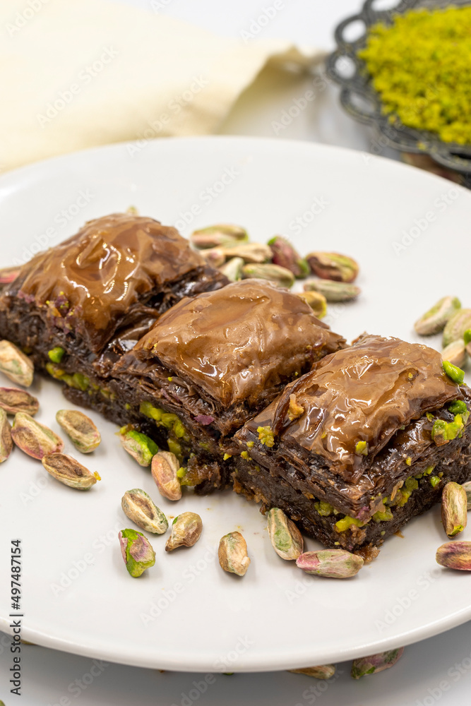 Chocolate baklava with pistachio on a white background. Traditional ...