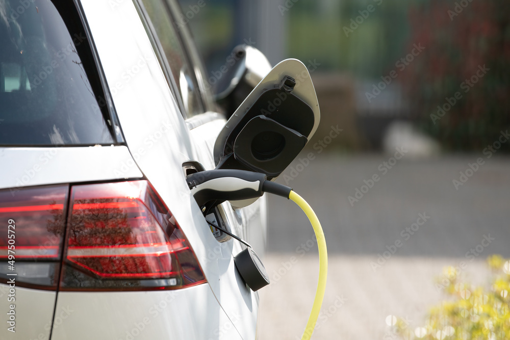 plug in adapter in car charge battery of electric car next to a ...