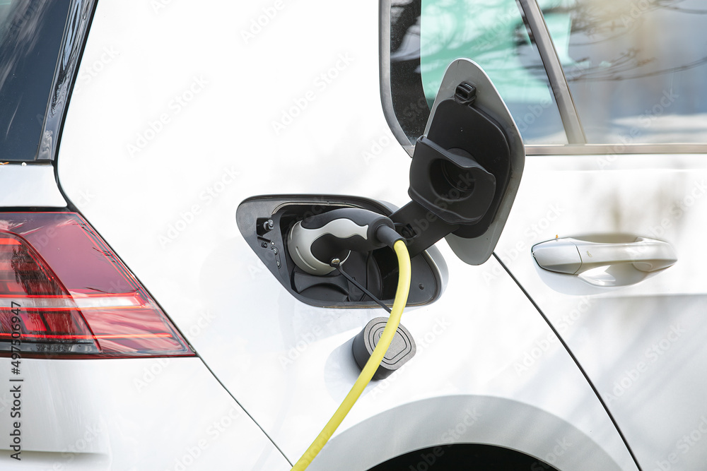 plug in adapter in car charge battery of electric car next to a ...
