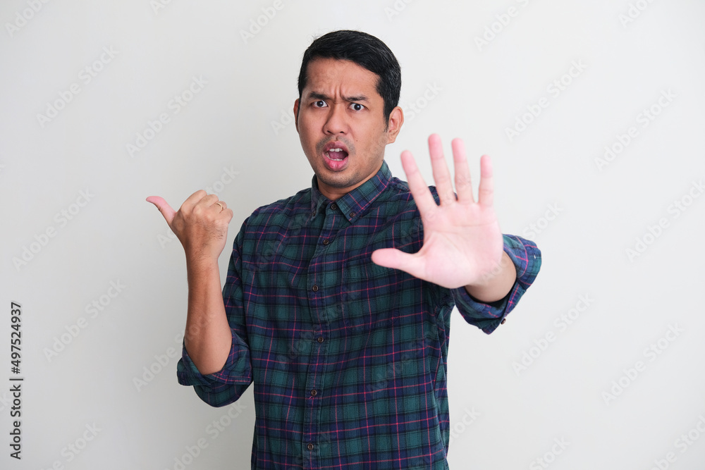 Adult Asian man making hand stop sign with worried expression while ...