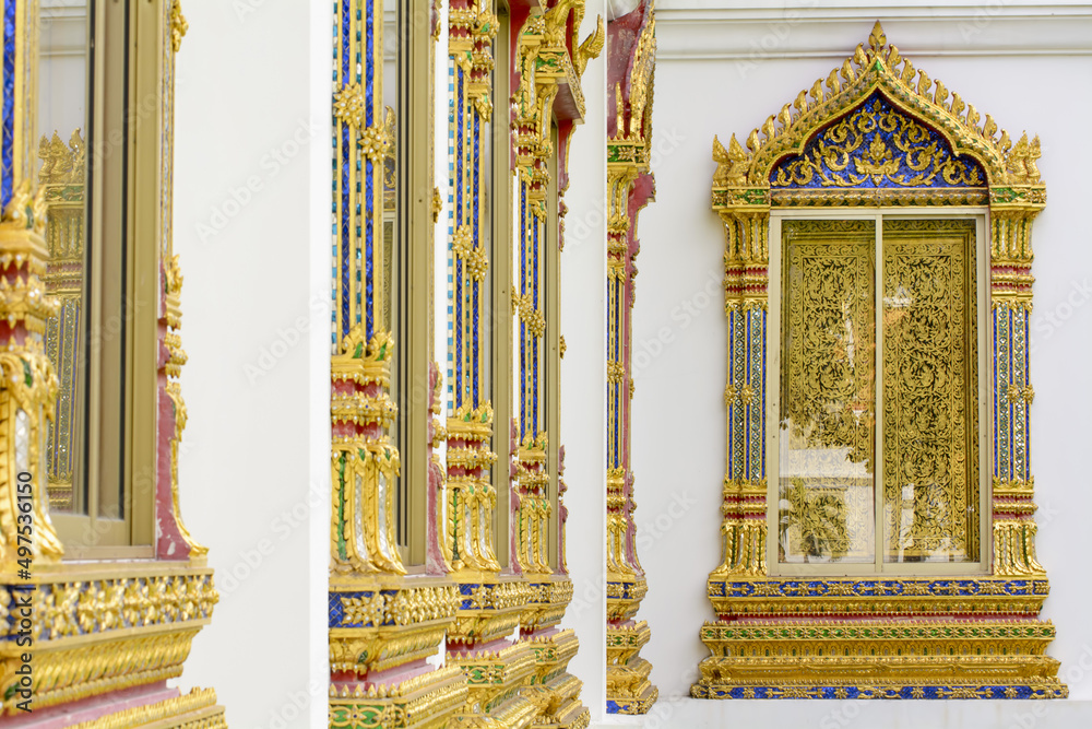 The ancient golden temple windows on a white wall in Wat Benchamabophit ...