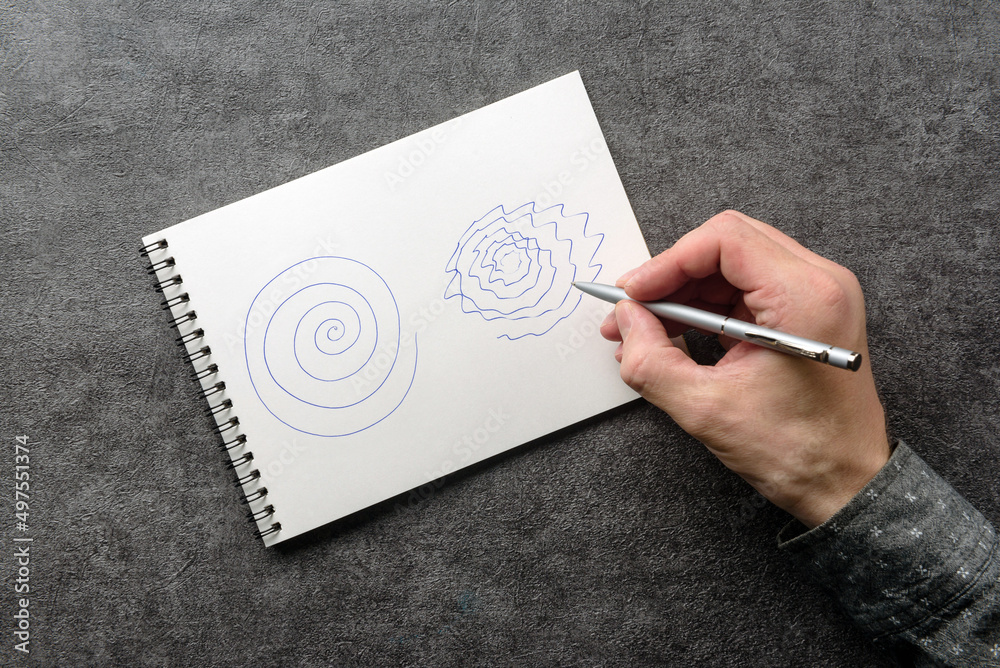 A man with trembling hands is trying to repeat the spiral drawing in a ...