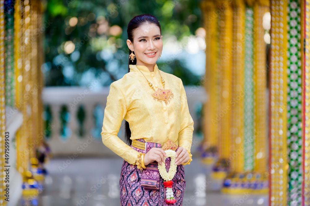 Foto de Attractive Thai woman in an ancient Thai dress holds a fresh ...
