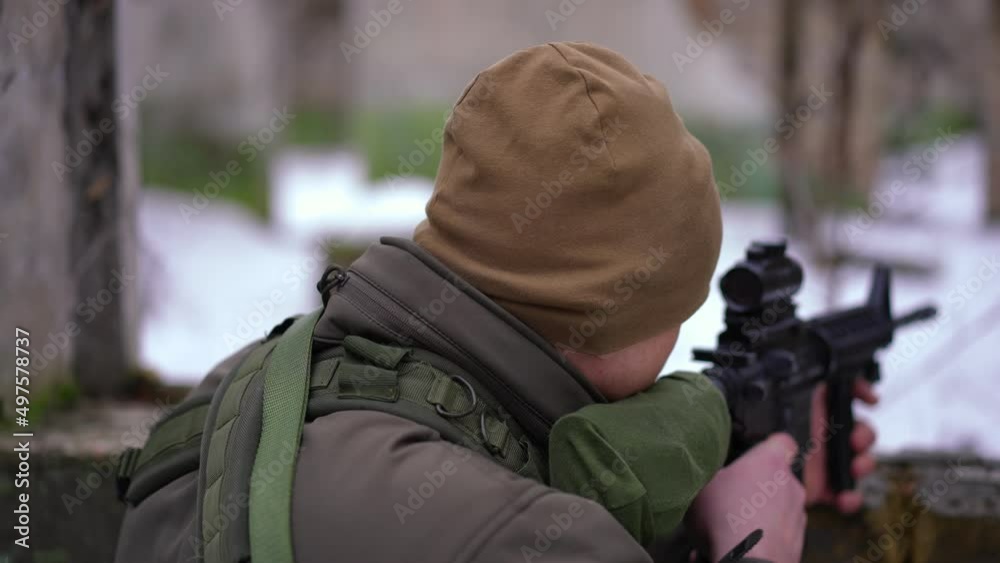 Back view concentrated young military man aiming as enemy putting gun ...