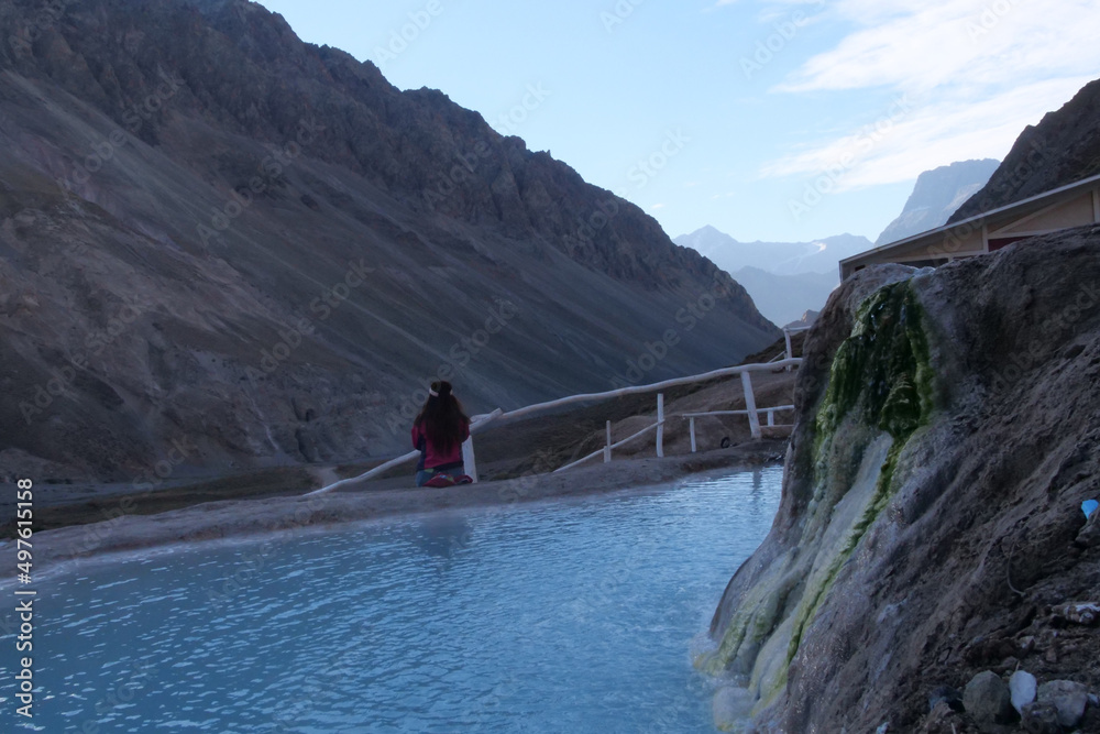 A tourist sitting with her back towards the viewer at the Thermal water ...