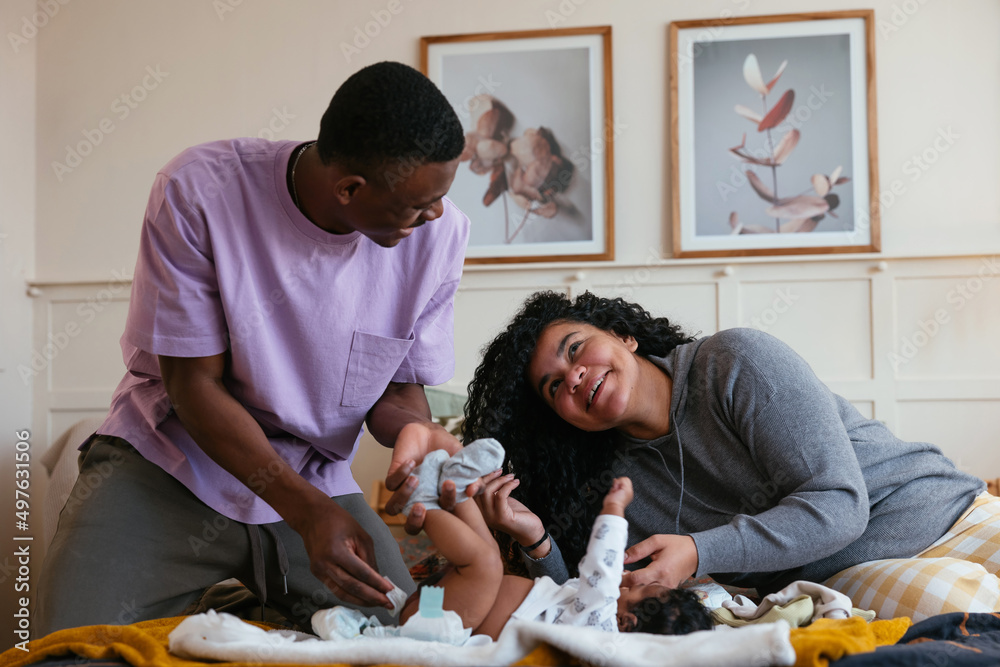 Black family changing diaper of baby Stock Photo | Adobe Stock