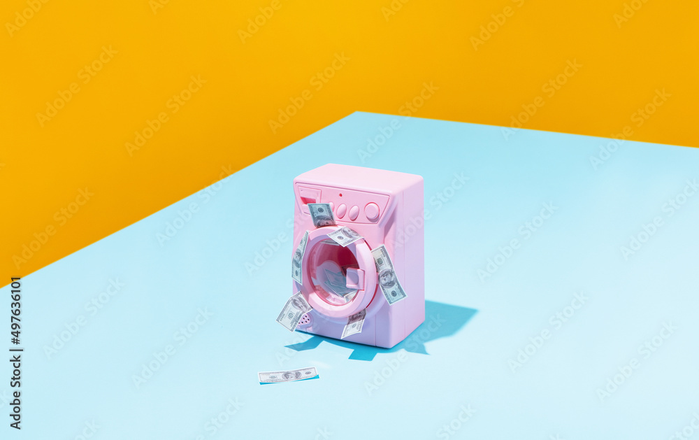 Washing machine washing dollar bills. Stock Photo | Adobe Stock