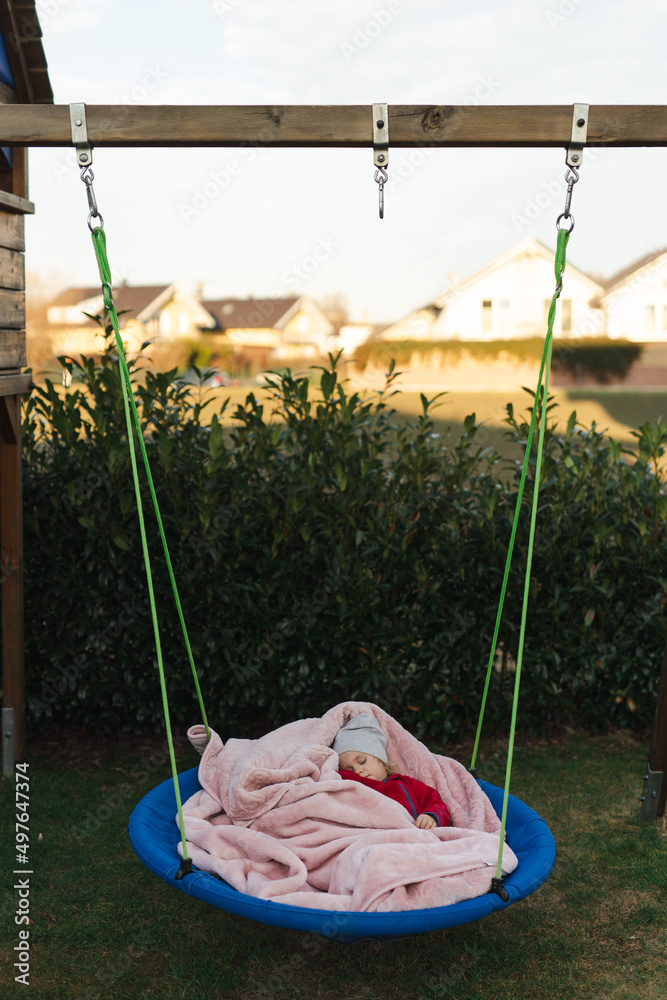 Cute toddler girl sleeping in a round swing outdoors Stock Photo ...